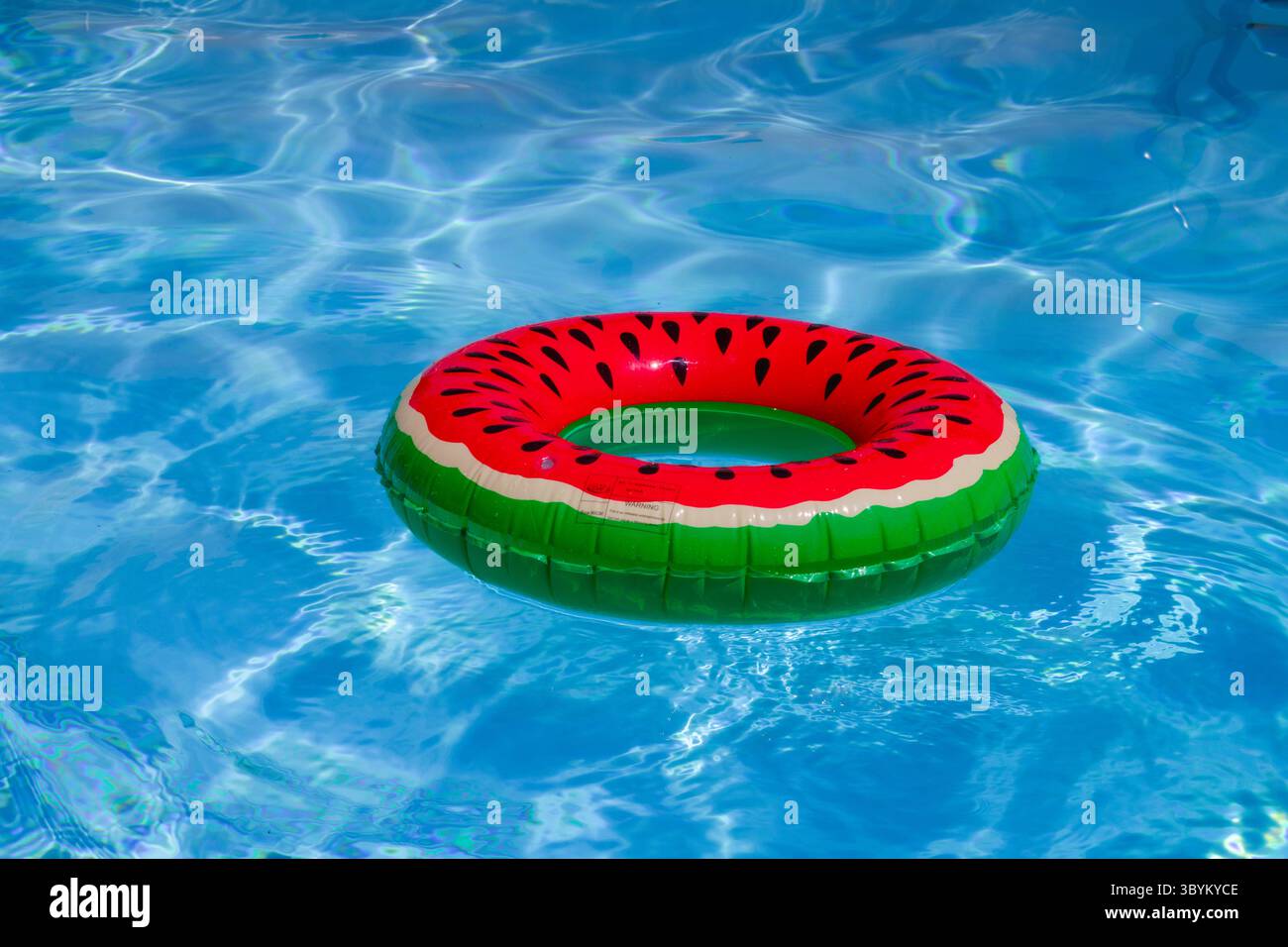 Summer day by the pool. Floating beach ball on pool water. Summer ...