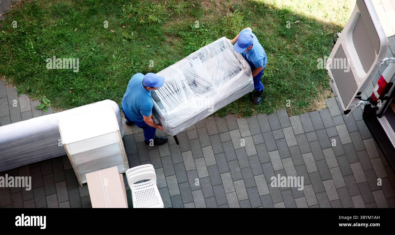 Hardworking Furniture Mover Transporting Sofa In Delivery Truck Through ...