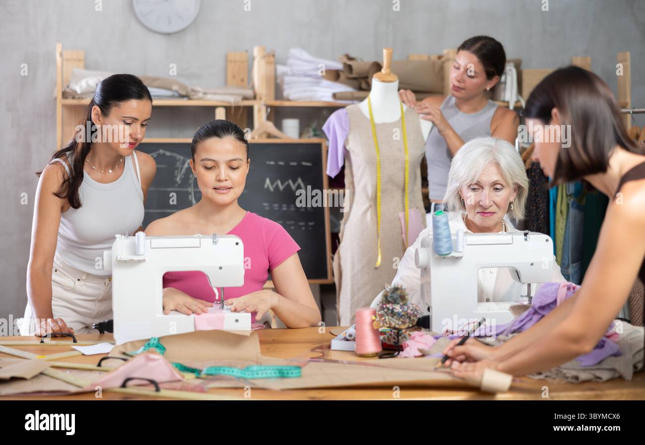 Female fashion students engaging at sewing class in small studi Stock ...