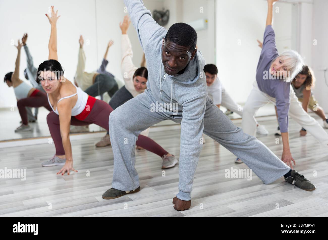 Group of active people performing a stretching exercise Stock Photo - Alamy