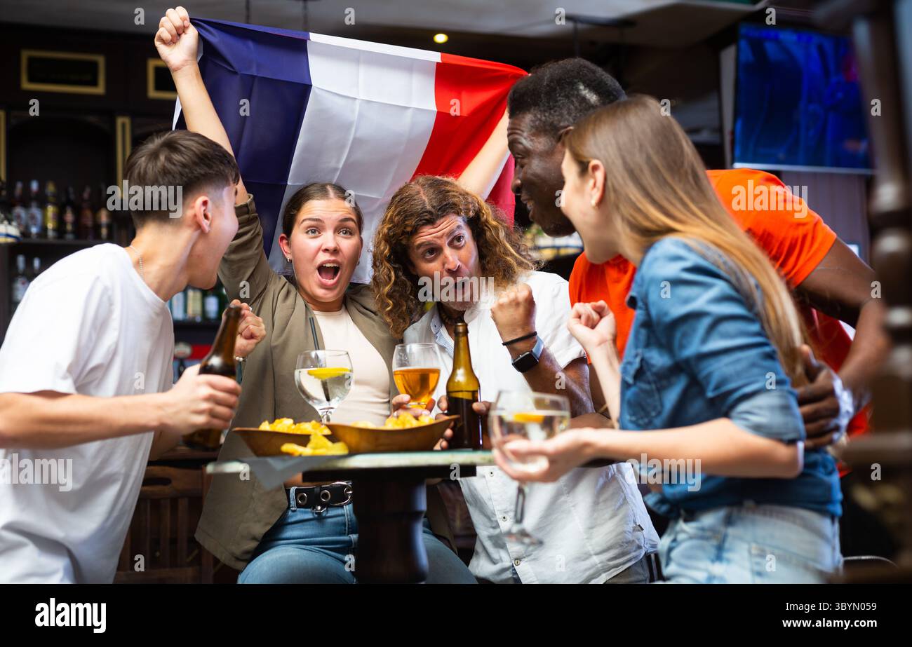 Cheerful multiracial football fans waving the flag of France with beer ...