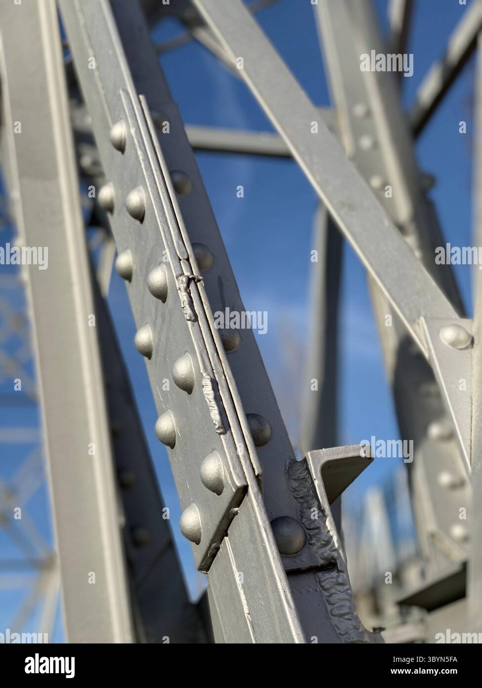 Close up of steel beams with rivets against blue sky, creating an ...