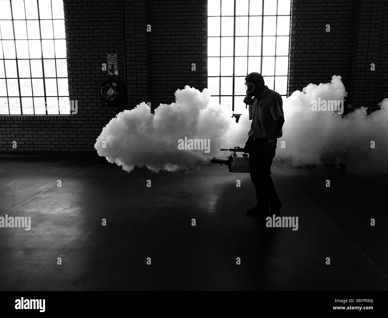Man fogging a building during covid Stock Photo - Alamy