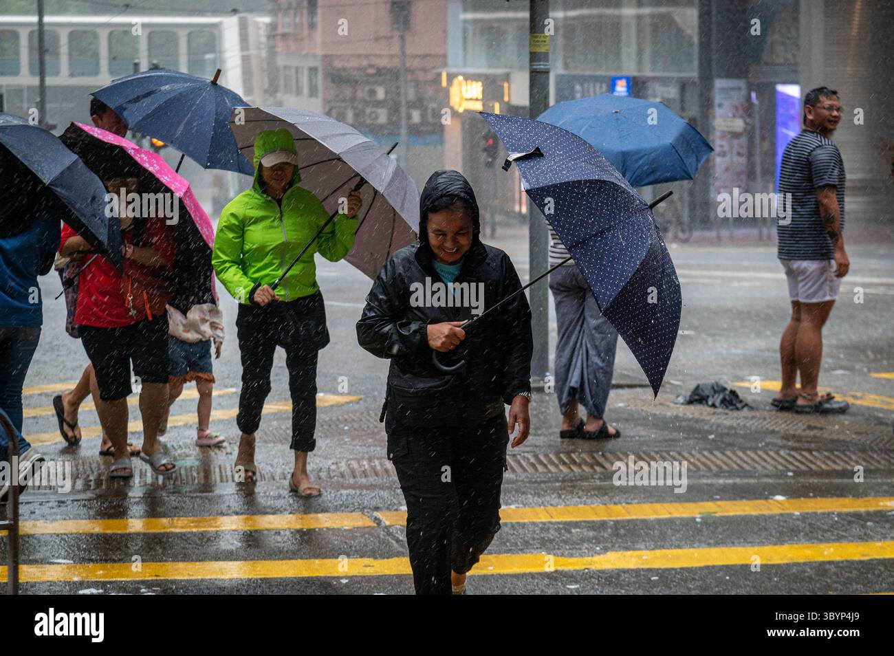 Hong Kong. 20th July, 2025. Residents deal with the pouring rain in ...