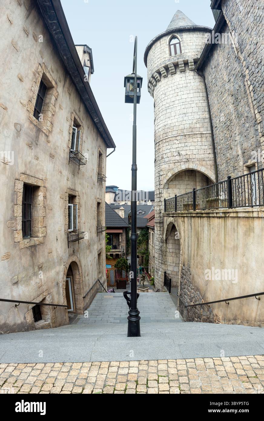 Historic stone alley with lamps and medieval buildings Stock Photo - Alamy