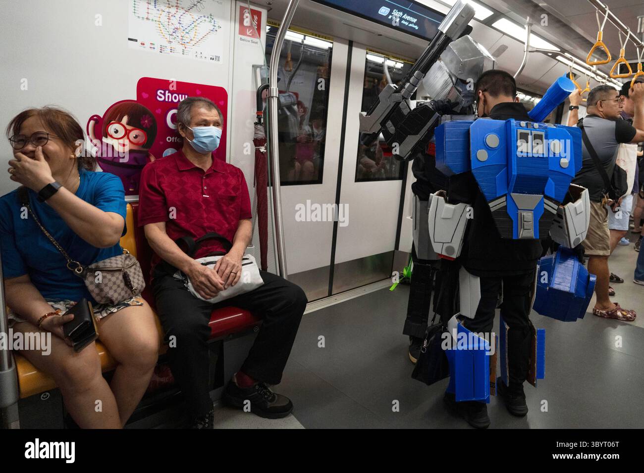 Wind Lau, center, left and Saif "Soundwave" take the MRT subway ...