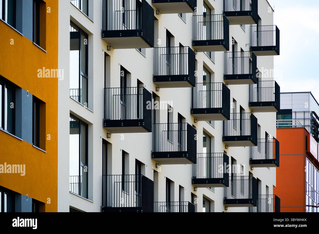 Modern apartment facade with pale walls and recessed black metal ...