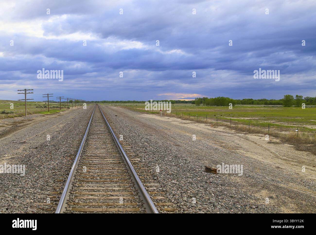 Railroad tracks with transmission lines to the one side and an ...