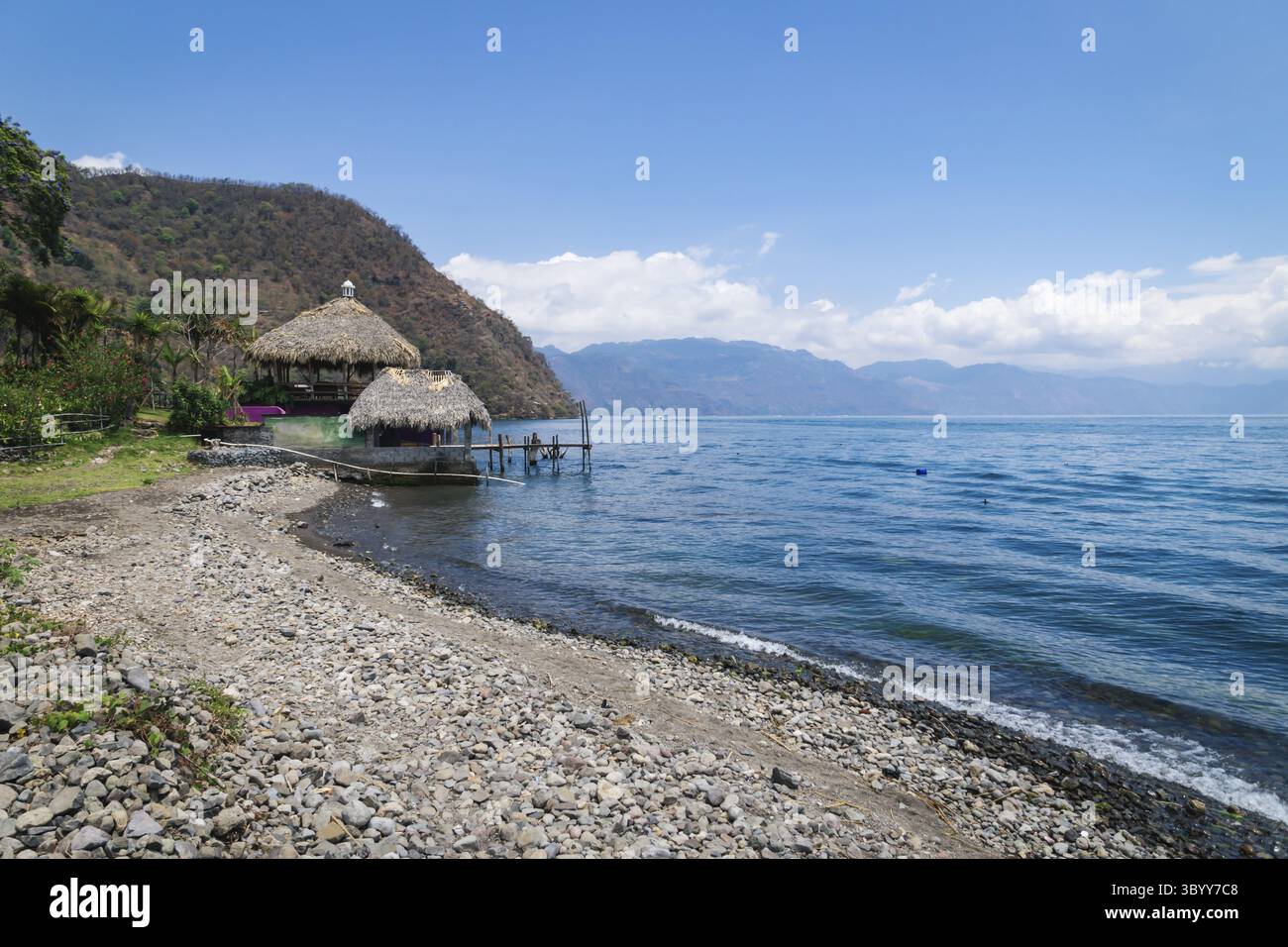 Jetty hut with straw roof at the stone beach of lake Atitlan with ...