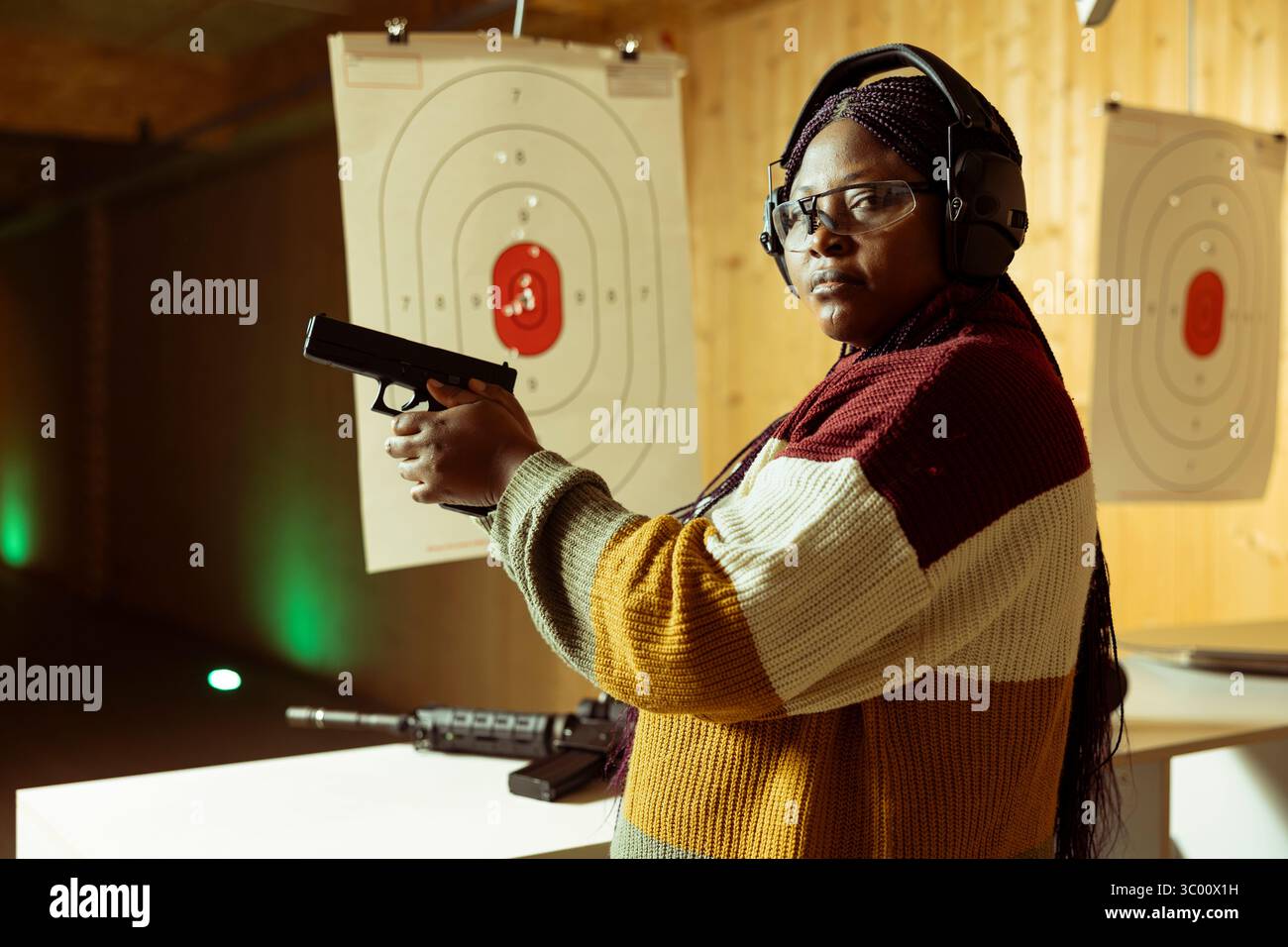 Portrait of woman in shooting gallery doing training, learning proper ...