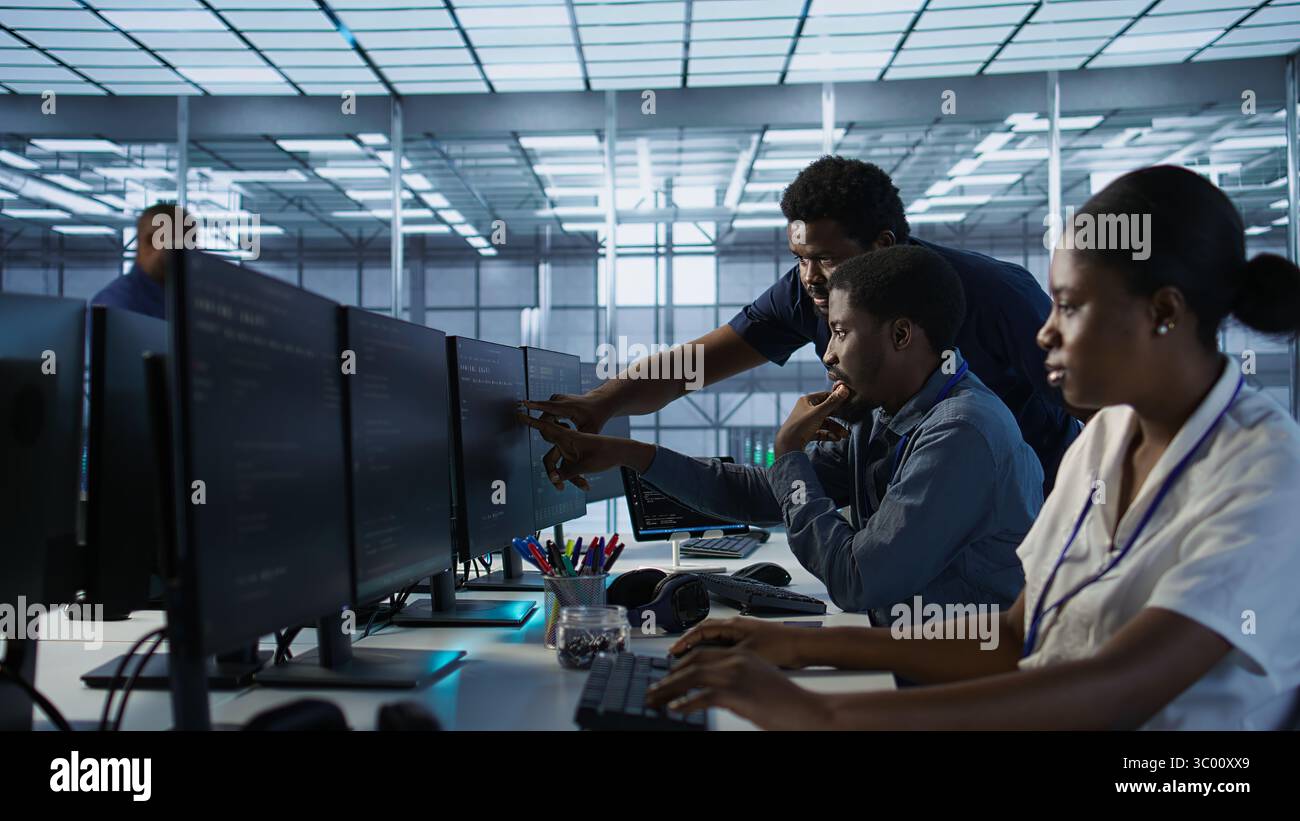 Manager supervising server room workers developing disaster recovery ...
