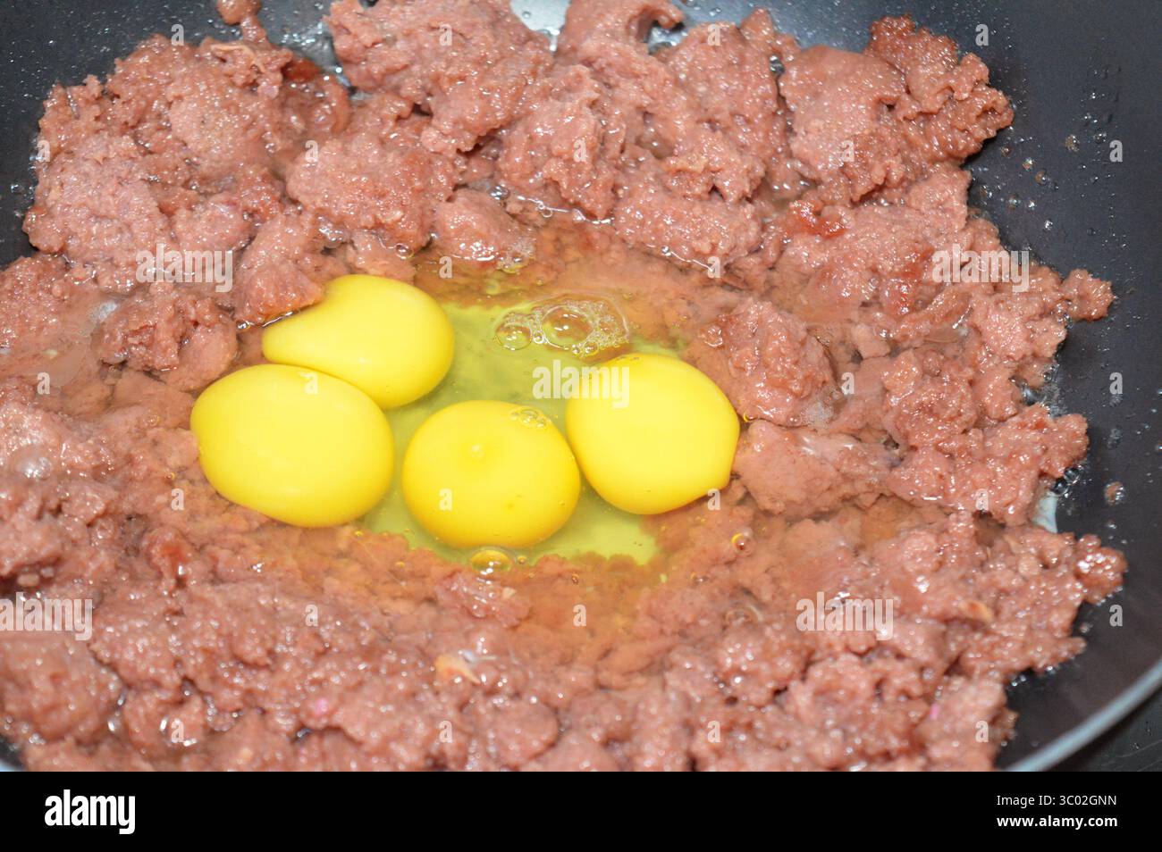 cooking eggs with corned salted beef, a variety of meat made from ...
