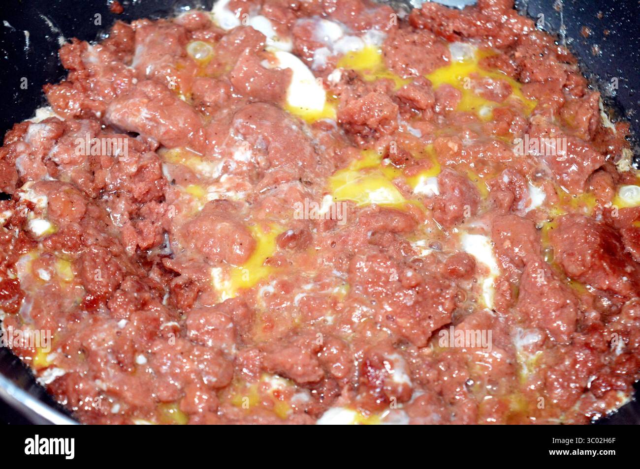 cooking eggs with corned salted beef, a variety of meat made from ...