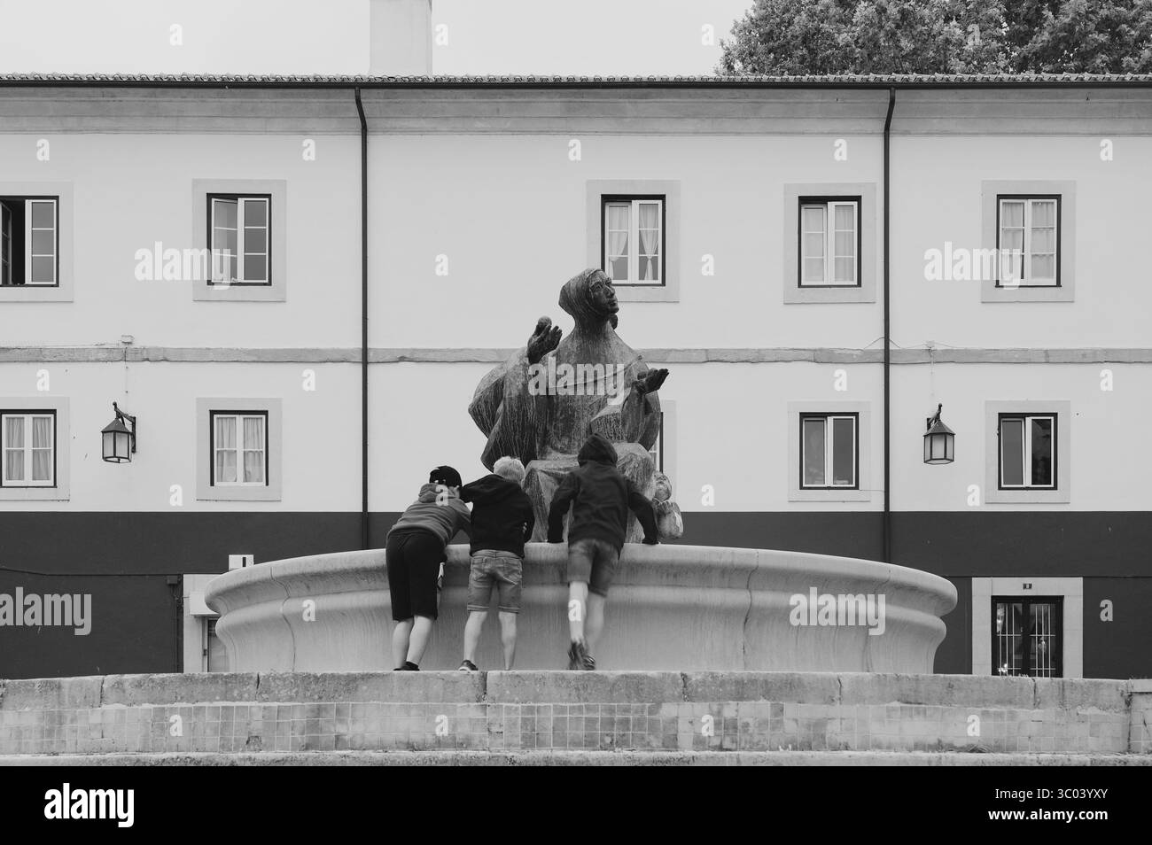 Children explore a fountain surrounding a bronze statue in the historic ...