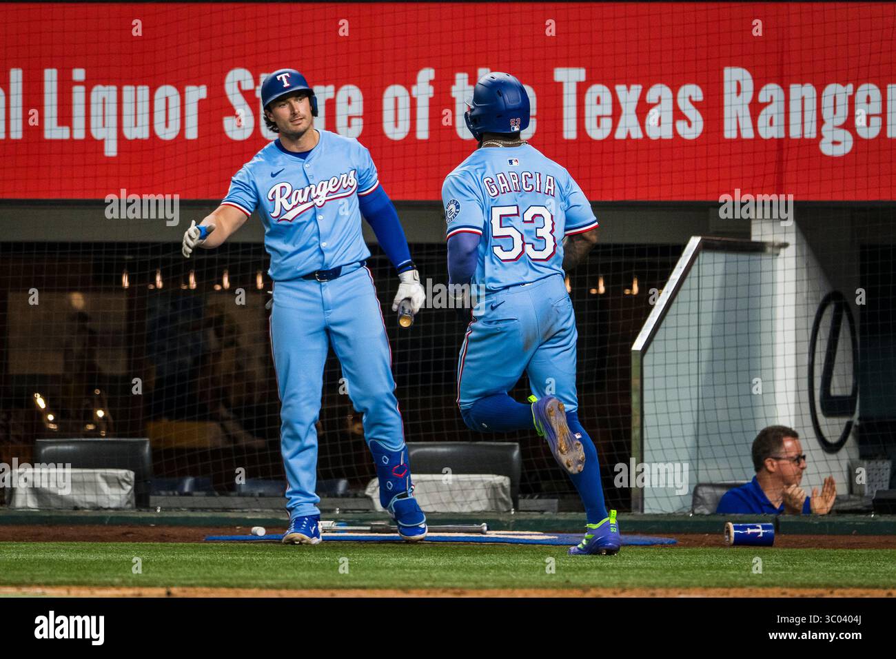 Texas Rangers' Adolis García (53) scores and gets a handshake from ...