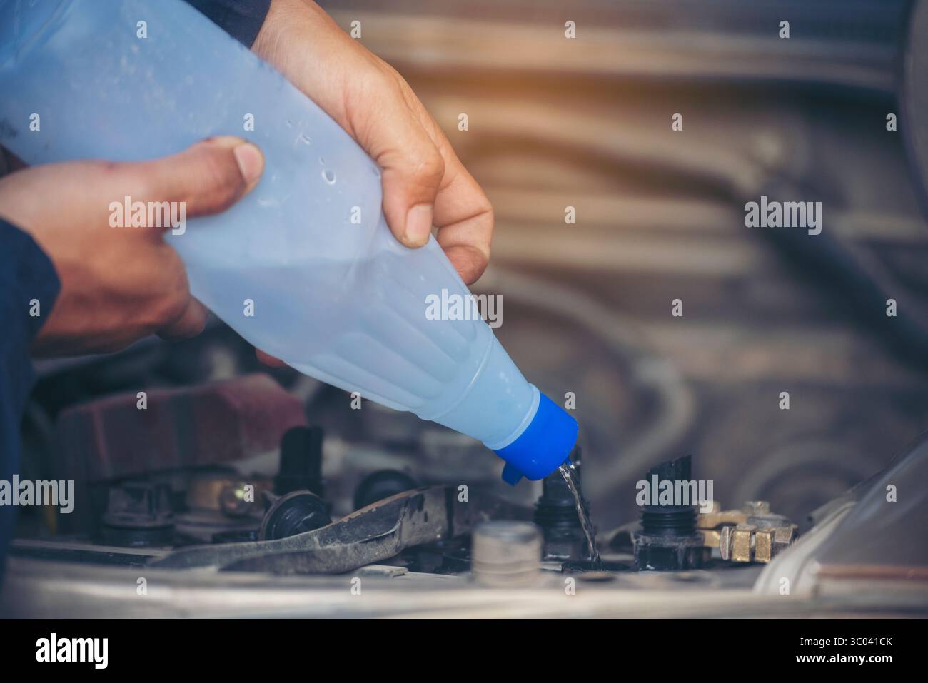 Car Mechanic man hands pouring Deionized purified Distilled water for ...