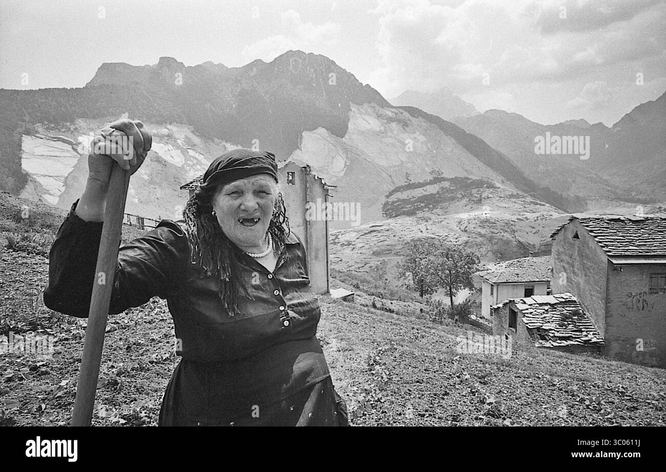 An elderly mower rests in the countryside; in the background the cut of Mount Toc from which the ...