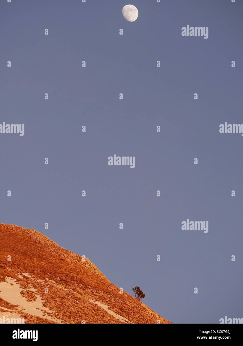 Lone moon and ridge light Stock Photo - Alamy