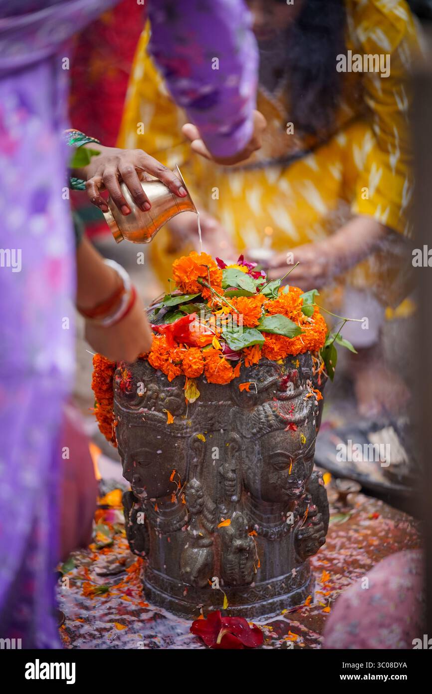Lalitpur, Nepal. 21st July, 2025. Devotees make offerings to Lord Shiva ...