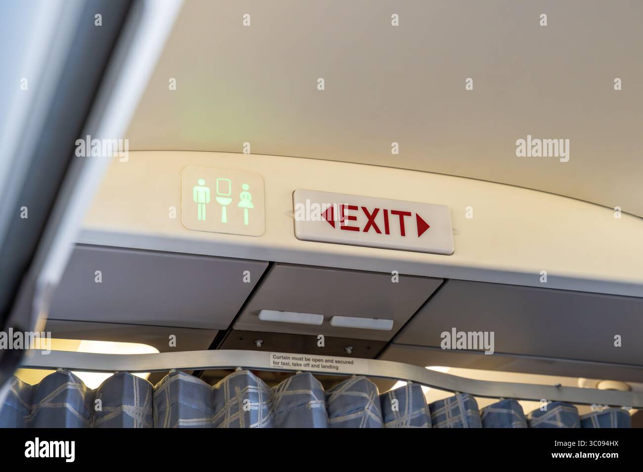 Airplane interior signage showing exit and lavatory icons. Flight ...