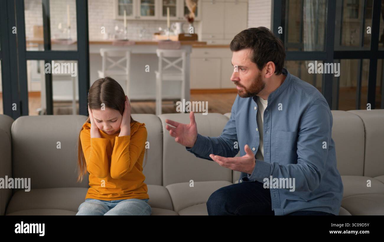 Furious Caucasian man father male screaming at sad afraid child girl ...