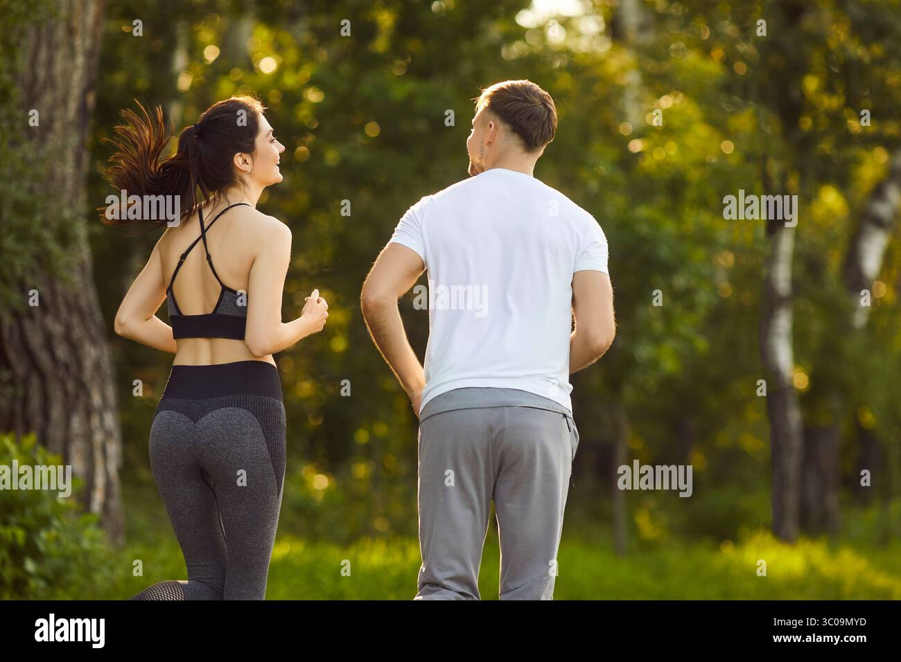 Sporty friendly people actively running outdoors in green forest, park ...