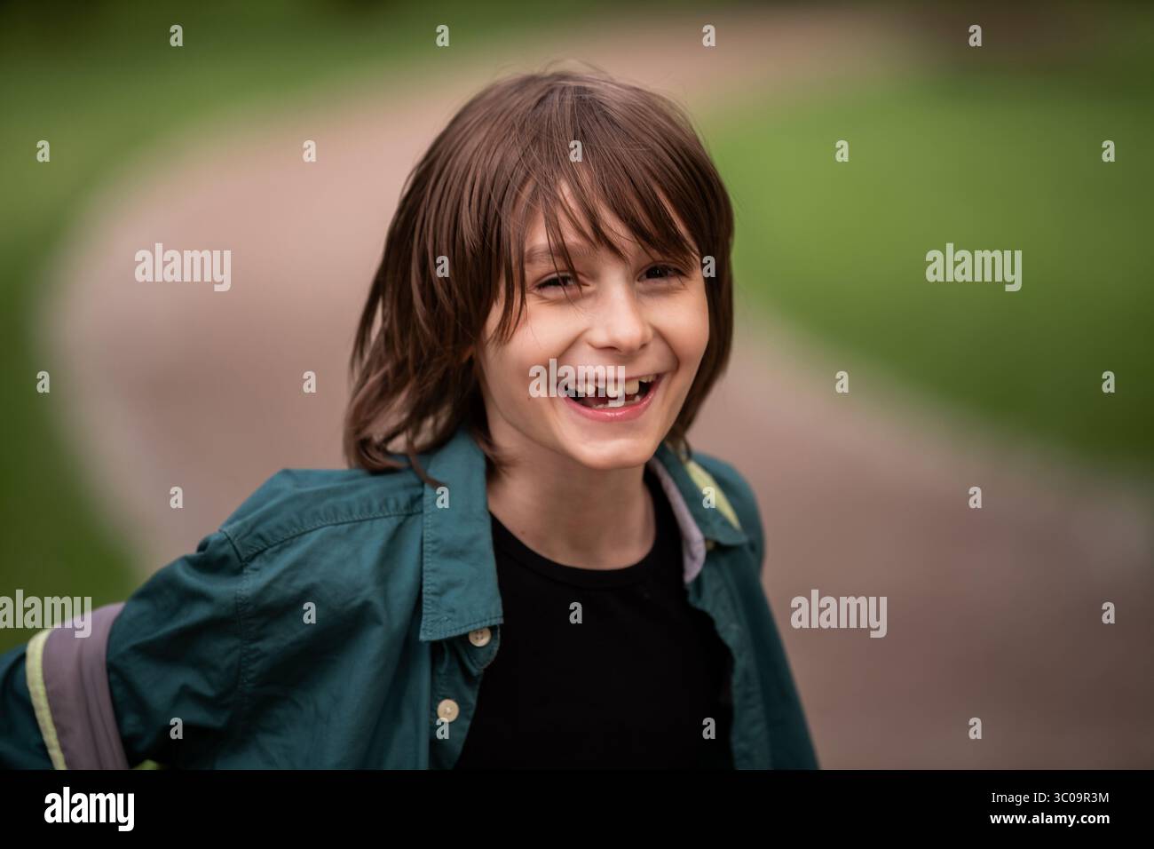 A happy caucasian boy with missing front teeth laughing outdoors. Close ...