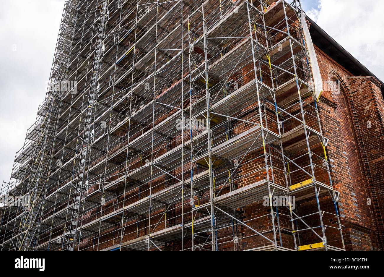 Metal scaffolding covering brick wall of historic building under ...