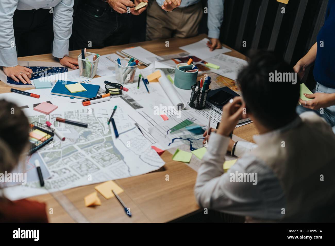 A multiracial business team collaborates on project solutions during a ...