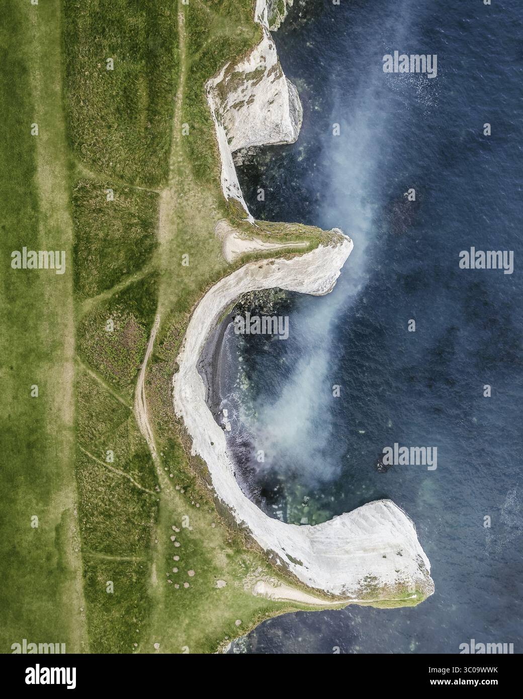 Aerial view of the chalk cliffs curving gently into the turquoise sea ...