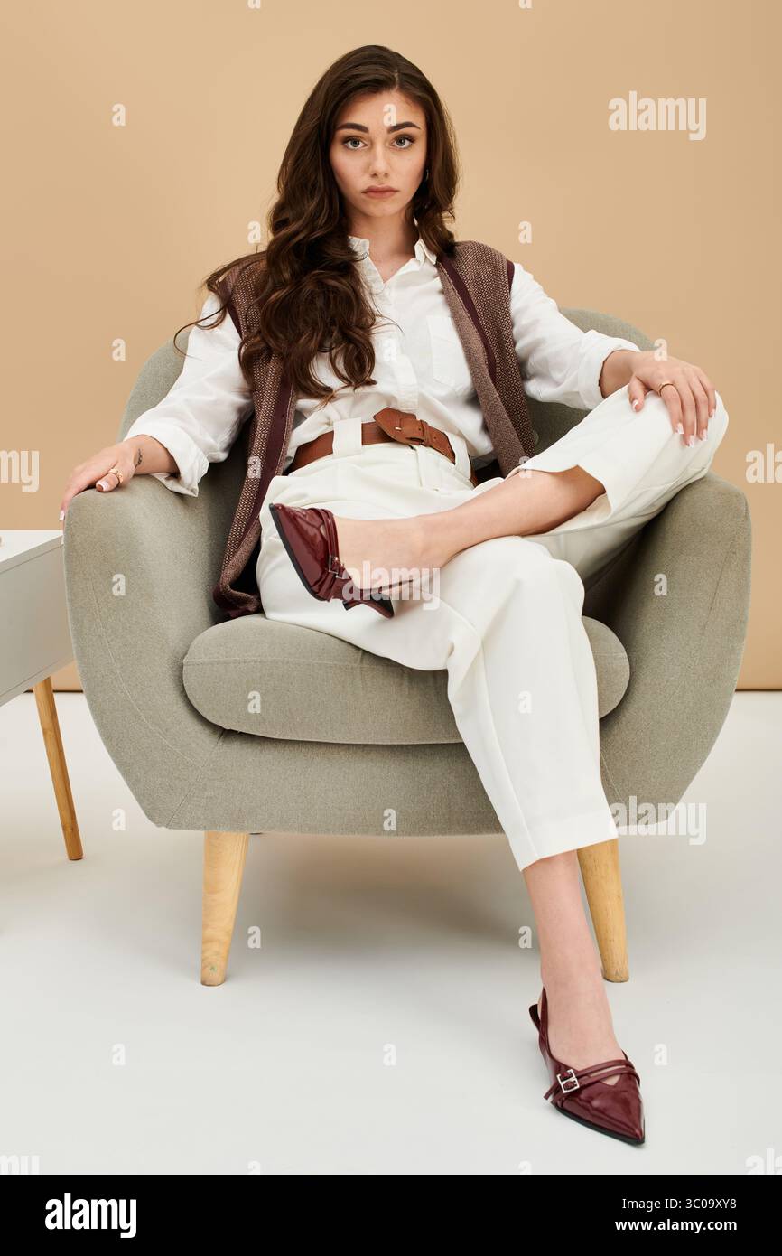 A beautiful young woman relaxes in a chic pose, highlighting her trendy ...