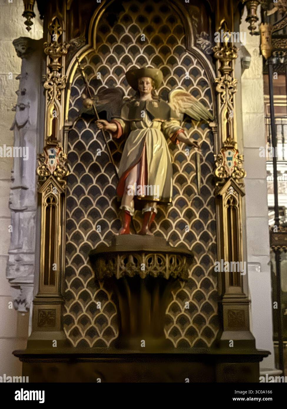 Painted sculpture of Archangel Raphael holding staff, set in ornate ...