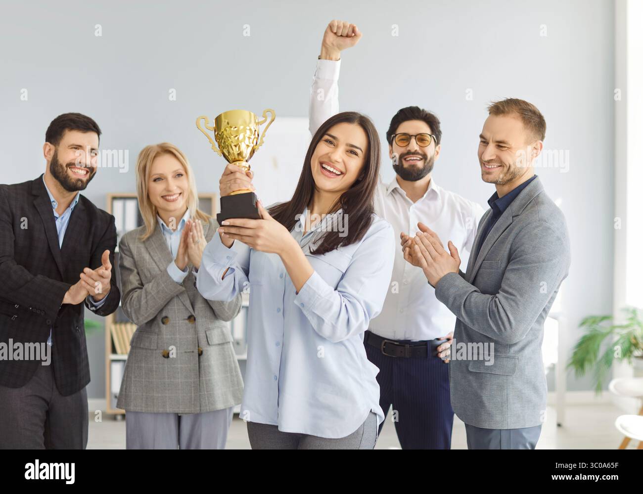 Happy business team holding golden trophy cup, clapping and celebrating ...