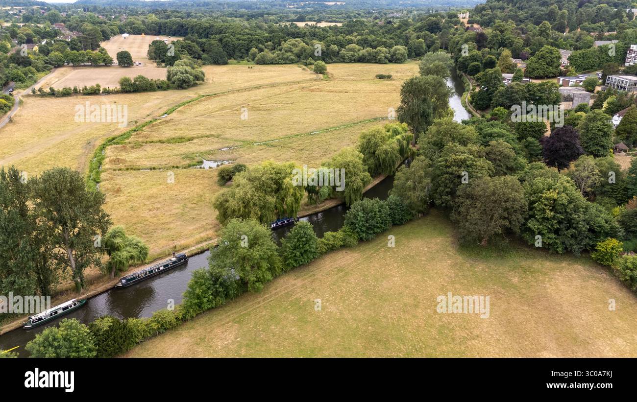Aerial view of a tranquil canal snaking through Guildford's lush fields ...