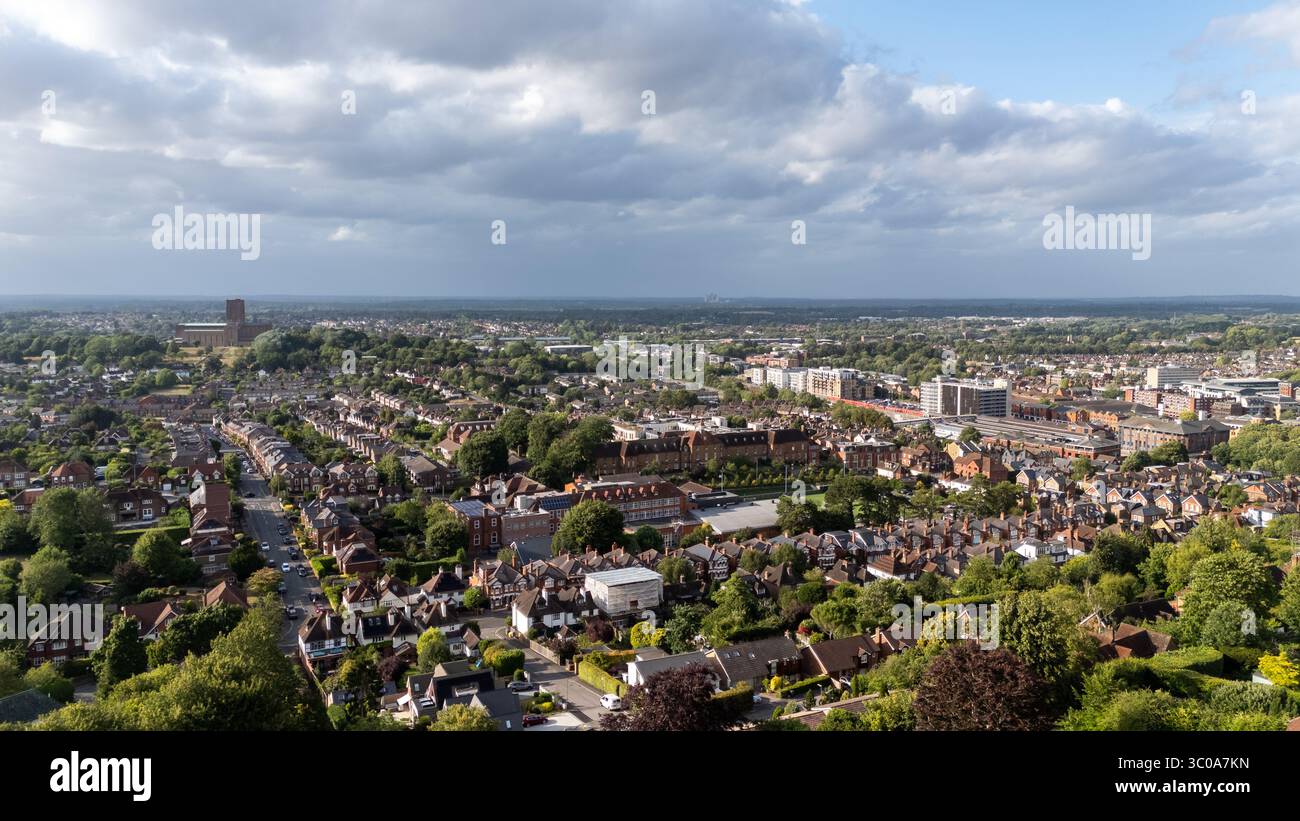 Aerial view of sun-kissed rooftops and verdant trees stretch towards ...