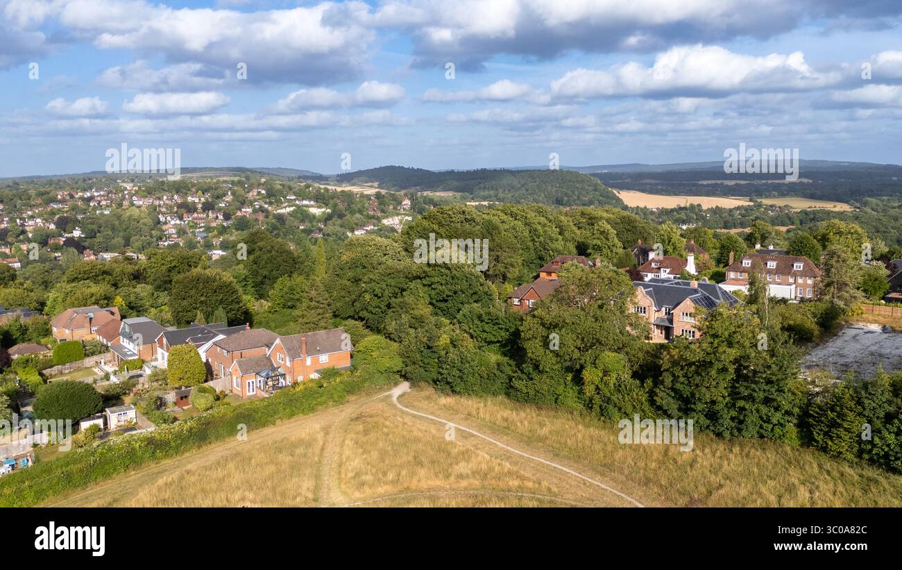 Aerial view of rooftops and treetops blending under a bright sky, homes ...