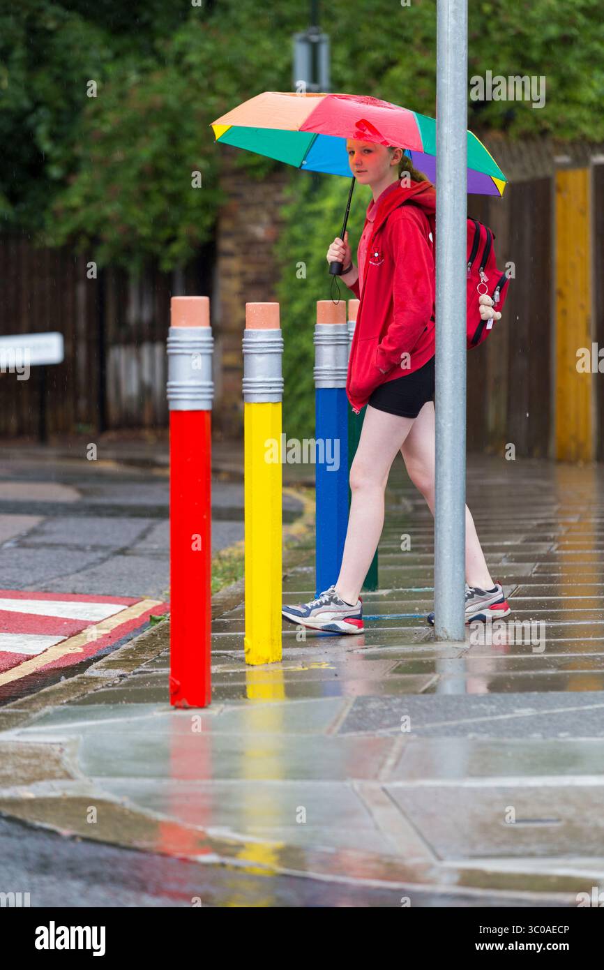 11 year old girl / school pupil with umbrella on raining wet day ...