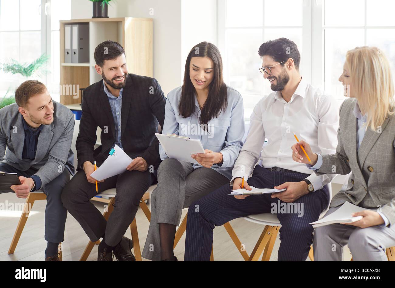 Business people sitting in a row and talking with each other preparing ...