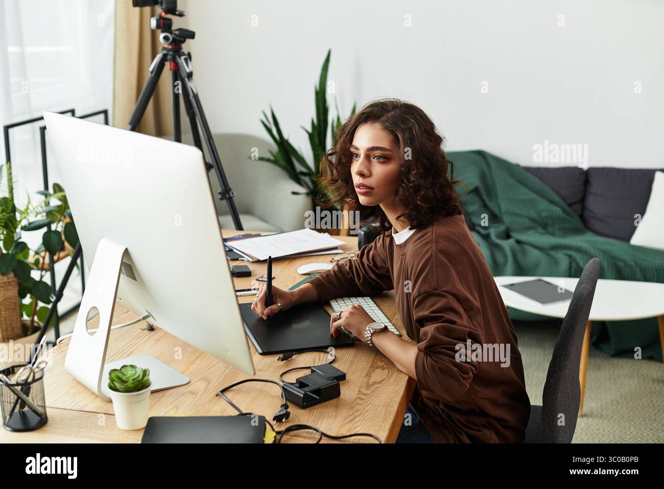 A talented artist focuses on retouching with a graphic tablet in her ...