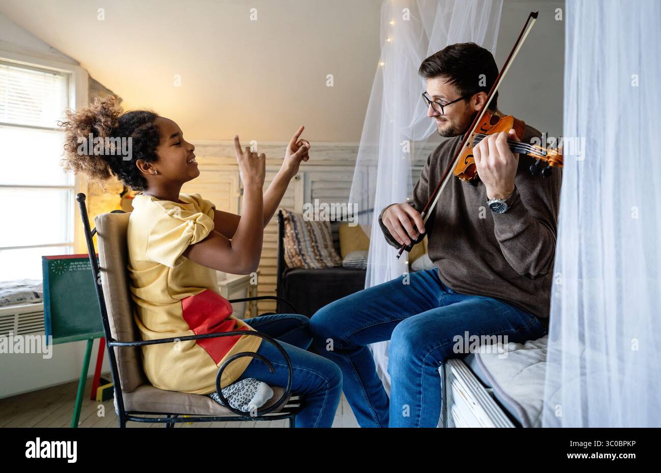 Private music man teacher giving violin lessons to African American ...