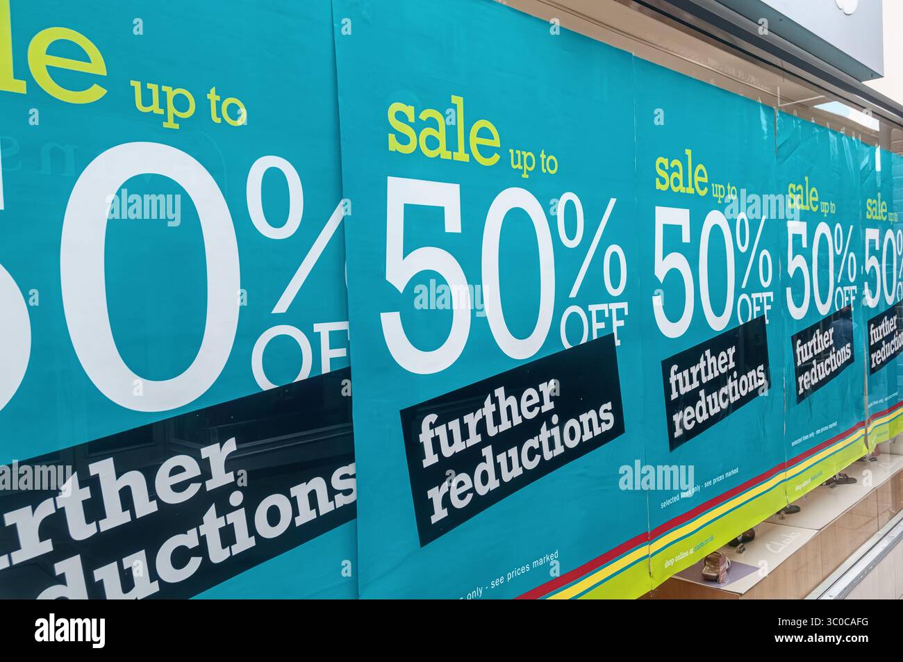 Sale and up to 50% off further reductions signs in a shop window in ...
