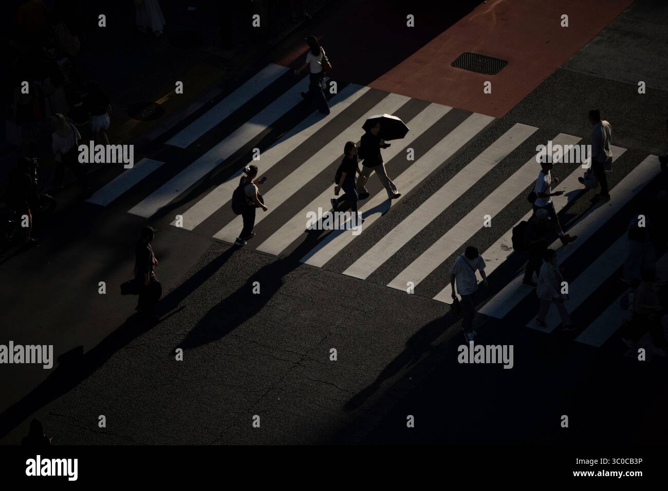 Pedestrians walk across a crossing in Tokyo, Monday, July 21, 2025. (AP ...
