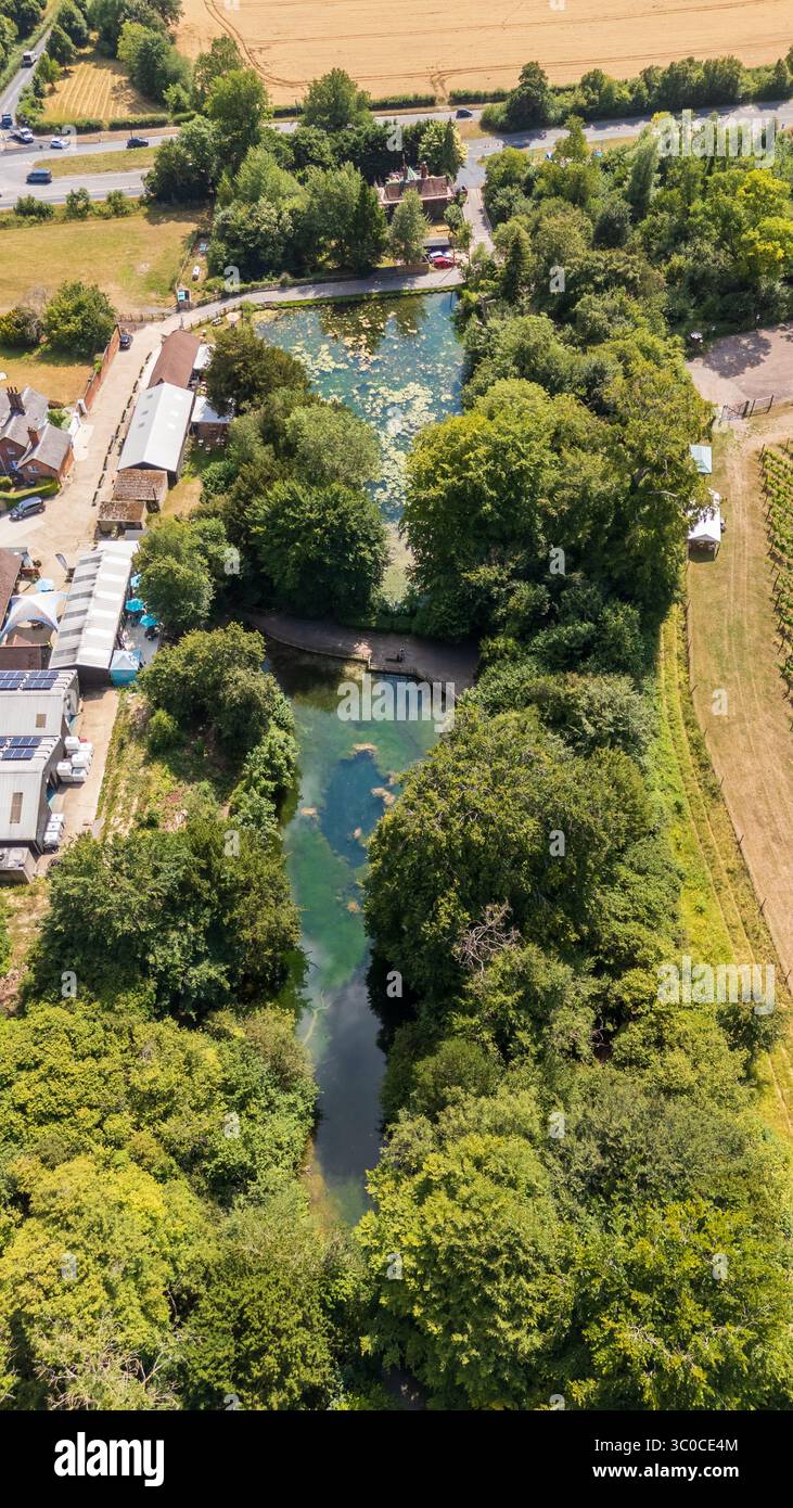 Aerial view of the serpentine river reflects the sky between verdant ...