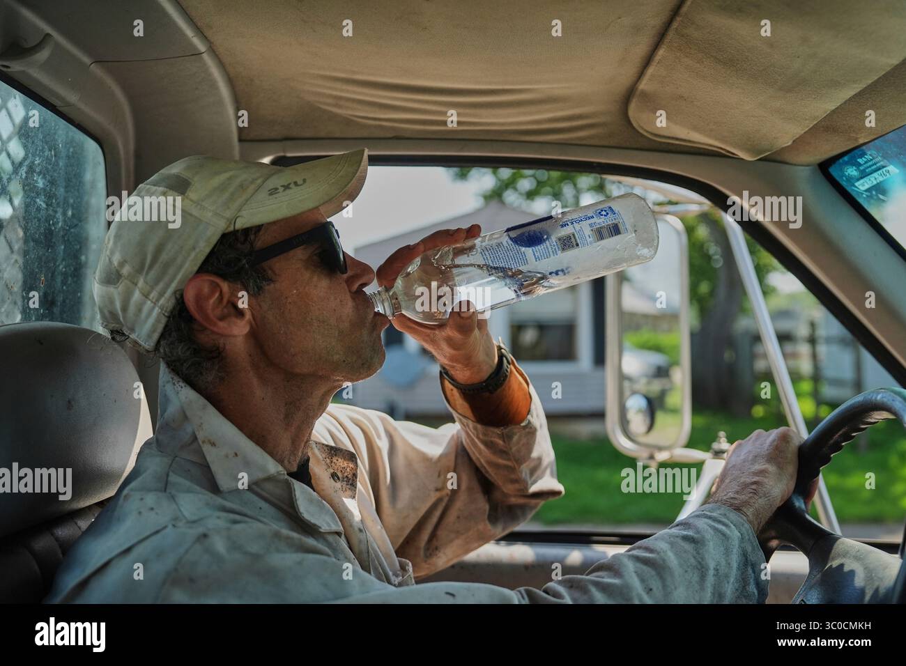 Isaac Barnes takes a drink of water after harvesting honeycomb from his ...