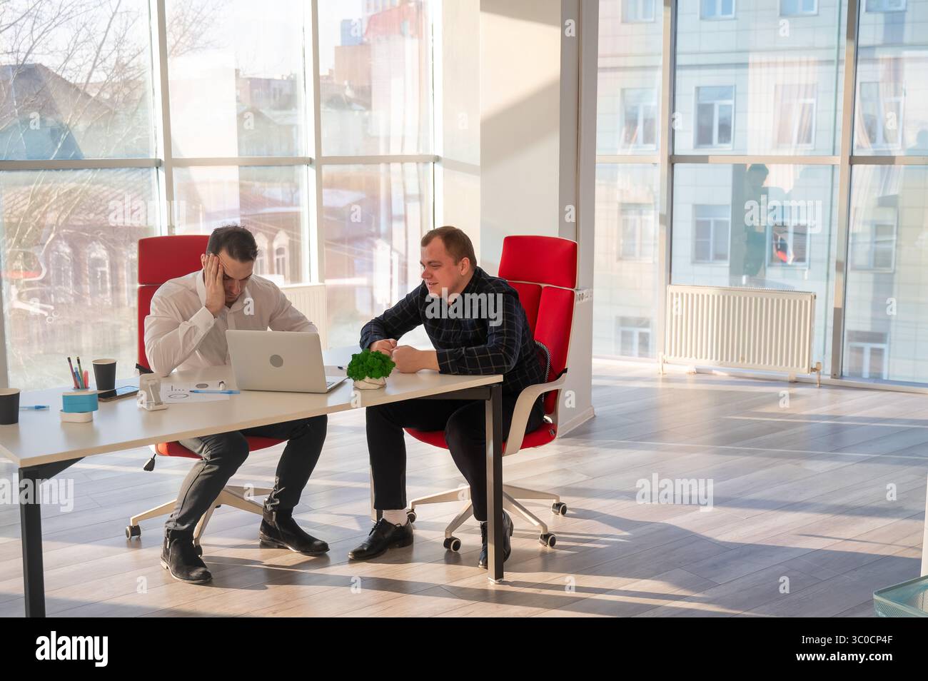 Two Caucasian men solve problems at work Stock Photo - Alamy