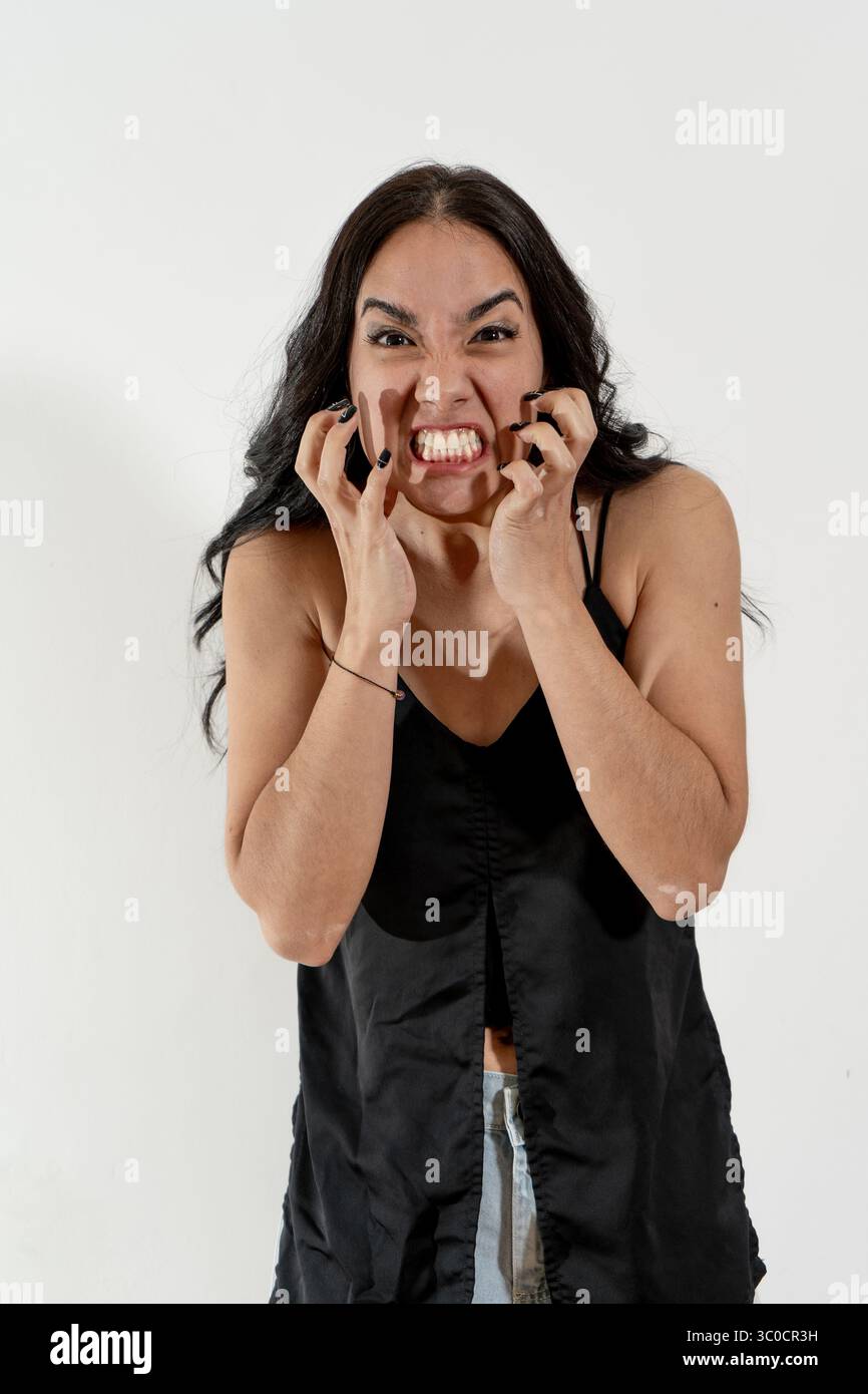 Young woman is feeling angry and frustrated, showing teeth and nails ...