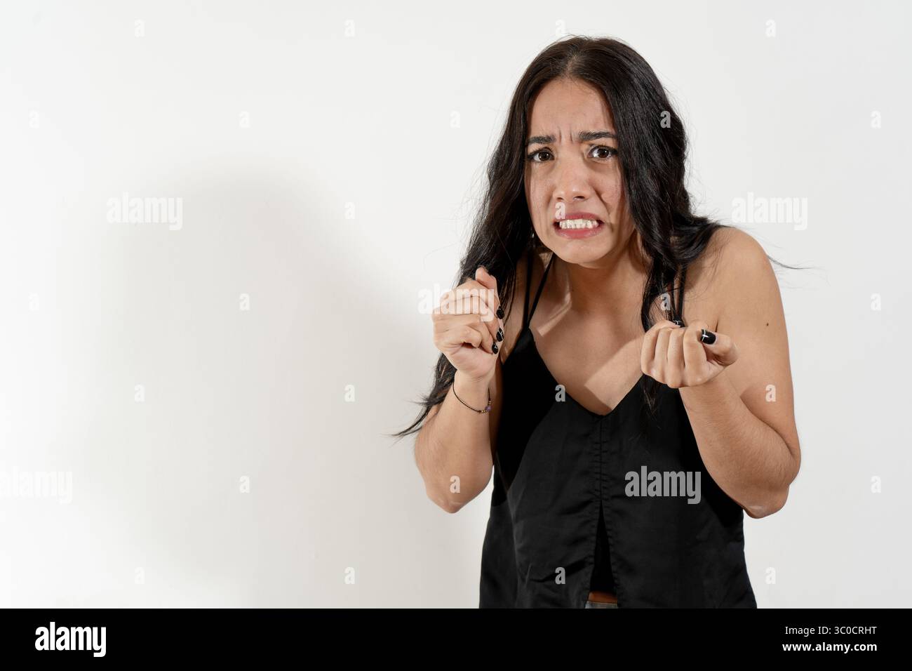 Studio portrait of a young latin woman grimacing and showing disgust ...
