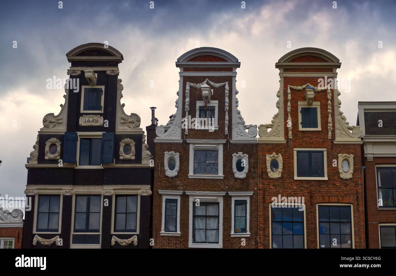 Traditional dutch gabled houses lining canal street, architectural ...