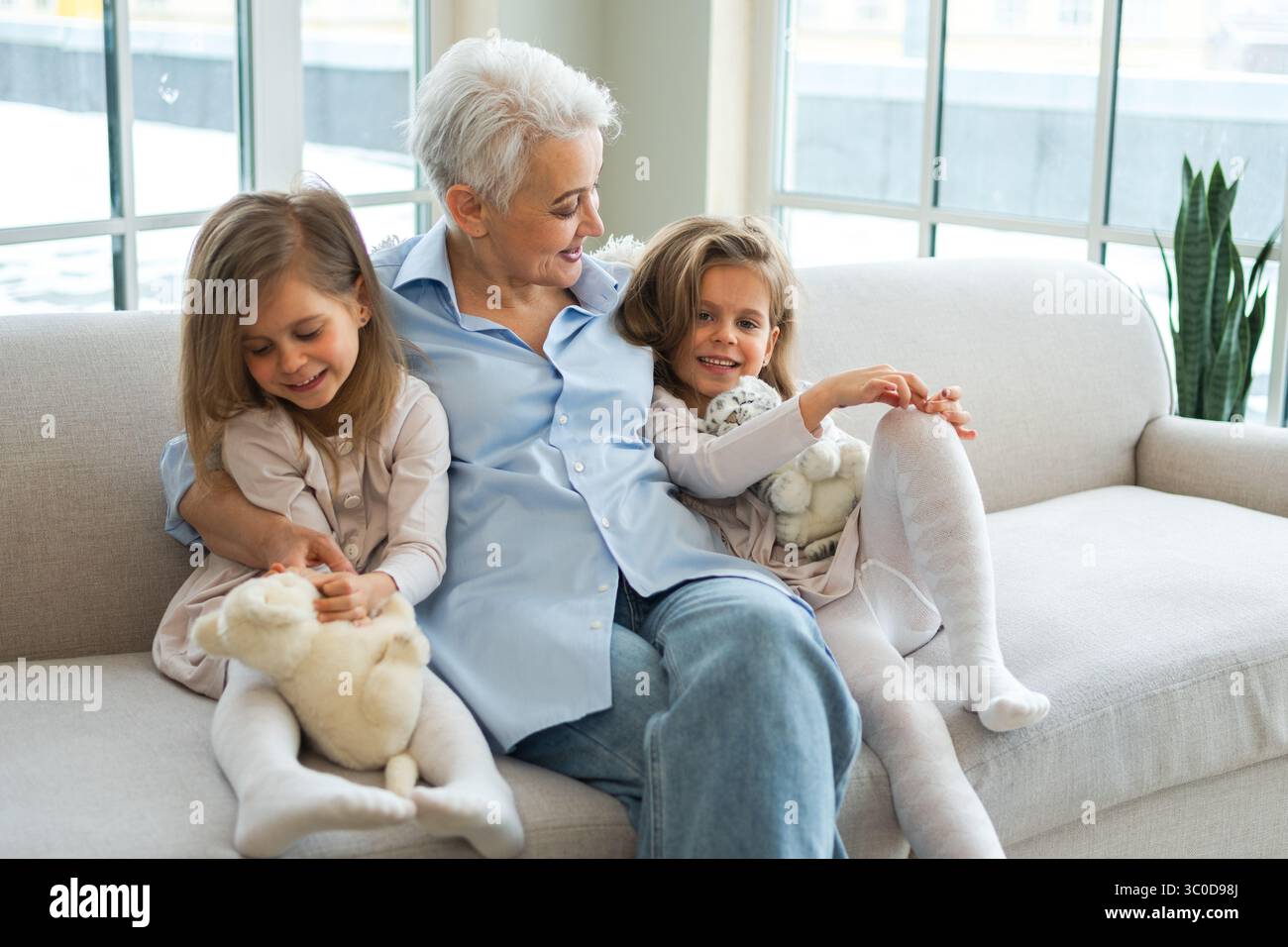 Happy family at home. Two little girls sisters twins grandmother ...
