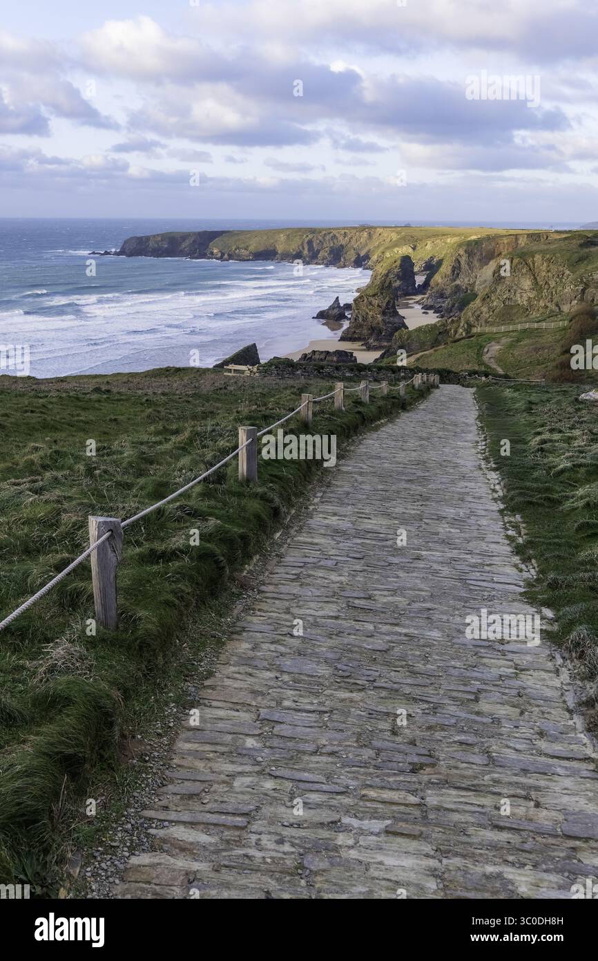 View of a stone pathway leading to the rugged coastline with dramatic ...